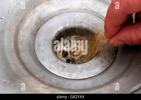 A man clears for the water flow to drain flooded houses during a ...
