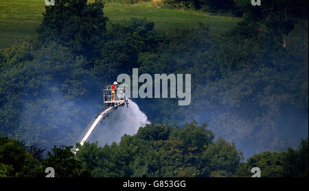 A fireman dampens down the scene of an explosion and fire where four ...