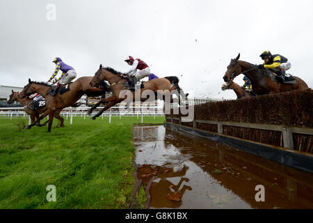 Runners and riders take the water jump during the Ultima Handicap Chase ...