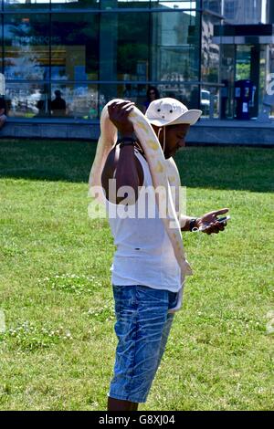 A man with a large python over his shoulders walking around the ...