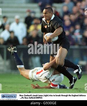New Zealand's Jonah Lomu tries to wrestle free of Italy's Christian ...