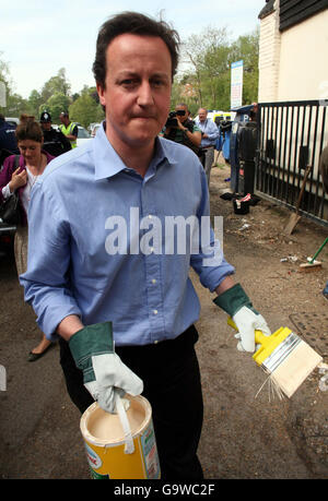 David Cameron paints over a graffiti-covered wall in Diss, Norfolk ...