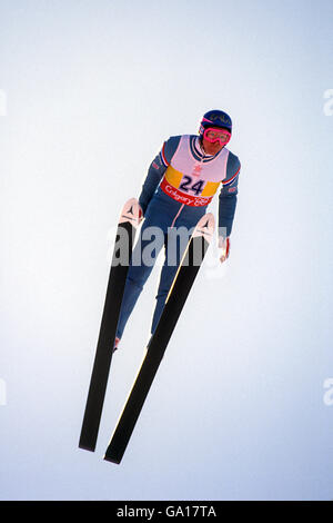 Britain's ski jumper Eddie The Eagle Edwards raises his arms, rejoicing ...