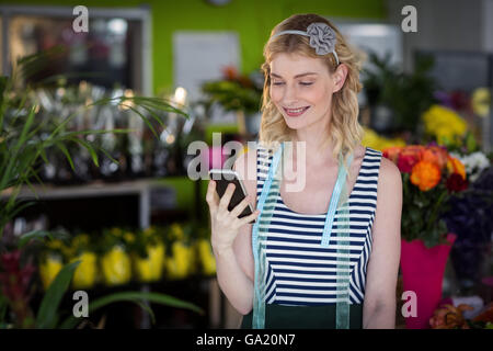 Smiling female holding mobile phone in the hand at electronics store ...