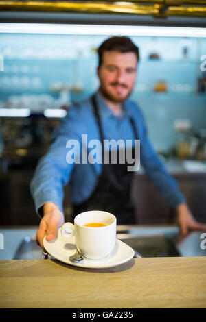 Waiter offering a cup of coffee Stock Photo - Alamy