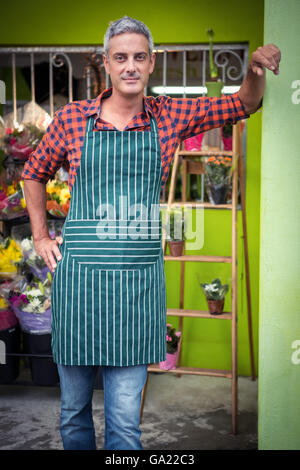 Smiling male professional leaning with hands in pockets at office Stock ...