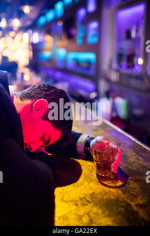 Man sleeping on bar counter Stock Photo - Alamy