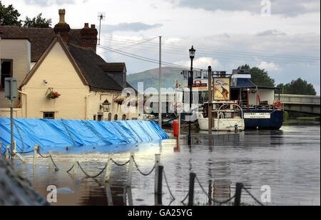 The swollen River Severn as flood defences are put in place along the ...