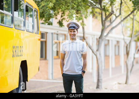 Smiling bus driver standing with hands in pocket in front of bus Stock ...