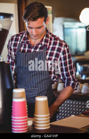 Thoughtful waiter standing at counter Stock Photo - Alamy