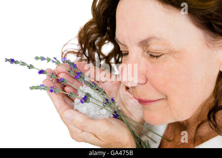Smiling mature woman smelling flowers lying on grass at field Stock ...
