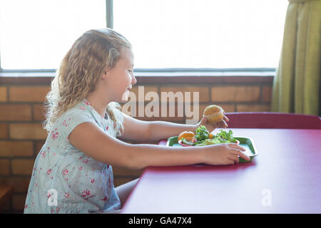 An elementary school girl is having breakfast with milk and funny ...