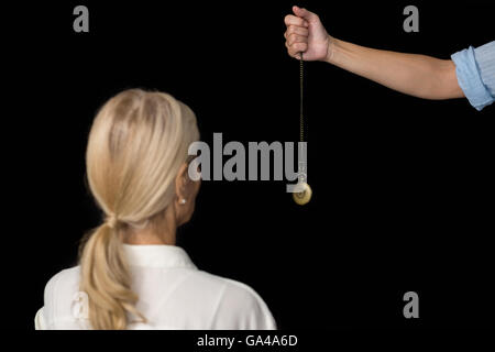 Hypnotherapist holding pendulum before her patient Stock Photo - Alamy