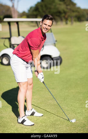 Young handsome man playing golf standing isolated over white background ...