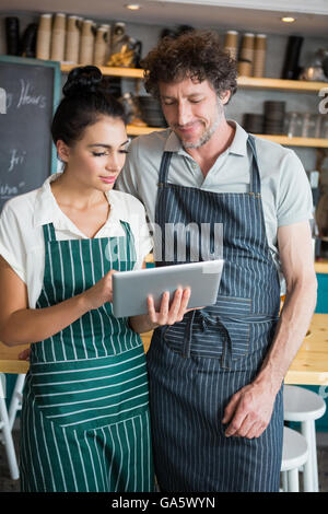 Waiter and waitress discussing over digital tablet Stock Photo - Alamy