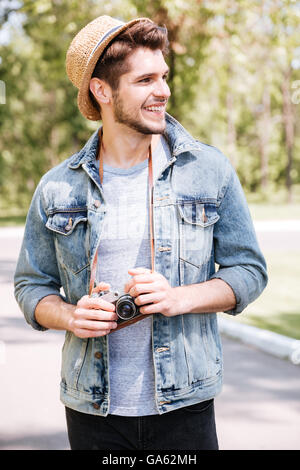 Portrait of a happy handsome man wearing t-shirt standing isolated over ...