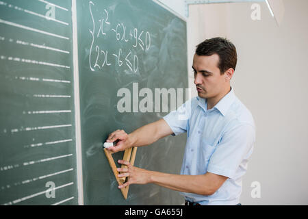 Young male math teacher in classroom Stock Photo - Alamy