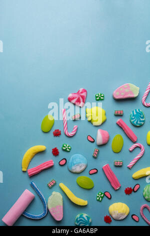 Mixed collection of colorful candy, on colored background. Flat lay ...