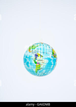 A small toy globe suspended on a string Stock Photo - Alamy