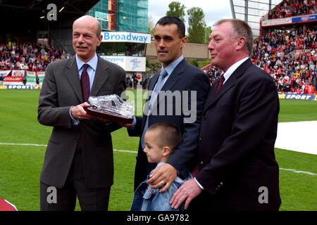 Clive Mendonca is presented with a trophy to acknowledge his ...