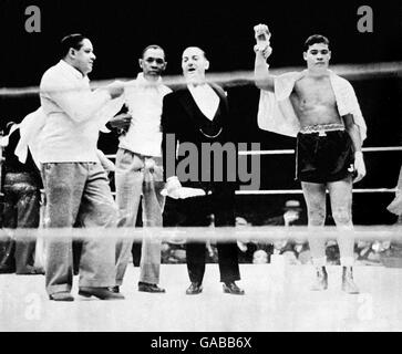 Announcer Harry Balogh raises Joe Louis's arm in token of victory after ...