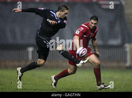 Swindon's Billy Paynter and Forest's Luke Chambers compete for the ball ...