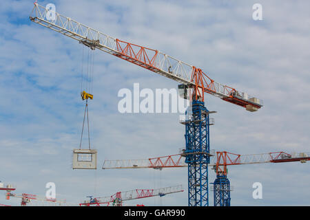 Construction site crane is lifting a precast concrete wall panel to ...
