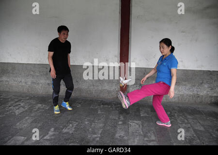 Chinese couple play Jianzi, a sport game in which players keep a ...