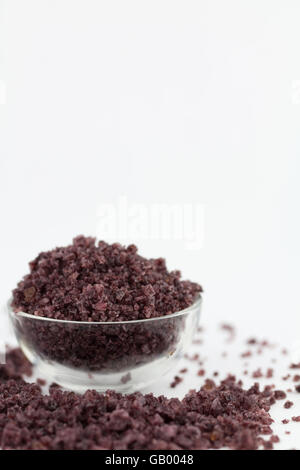 Spilled white sea salt on a black background. clear crystalline pebbles ...