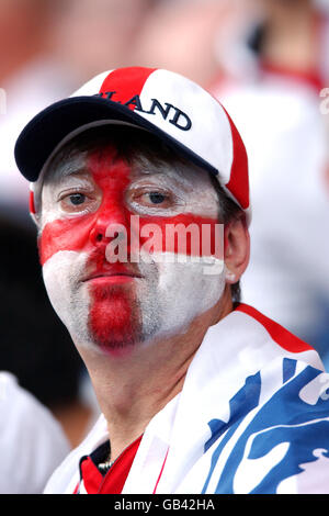 An England football fan with a painted face and wearing a colourful wig ...