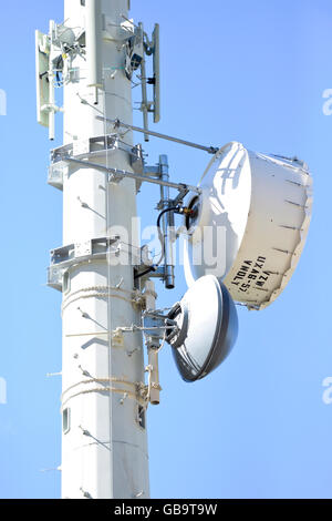 A telecommunications tower with microwave dishes and mobile phone ...