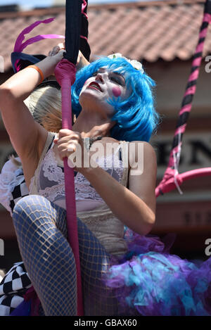 An acrobat is performing tricks on a hoop at the Summer Solstice Parade ...