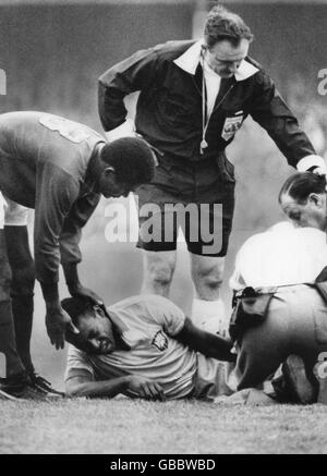 Referee George McCabe looks on as Brazil's Pele receives treatment ...