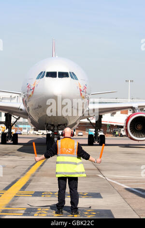 A plane is marshalled onto its stand by a marshaller from the Airside ...