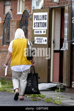 A woman arrives at a polling station to vote in the provincial election ...