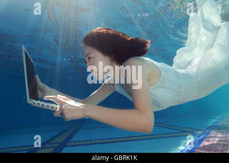 Young women use computers under water Stock Photo - Alamy