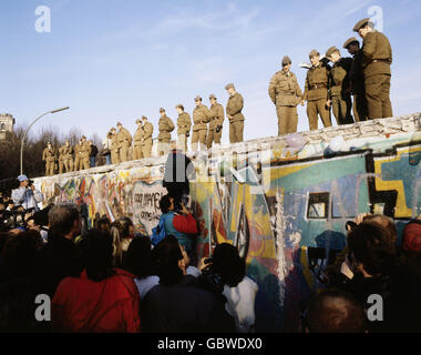 Border soldiers and people on the Berlin Wall at Brandenburg Gate, the ...