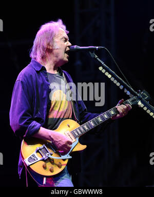 Neil Young on stage singing and playing guitar Stock Photo - Alamy