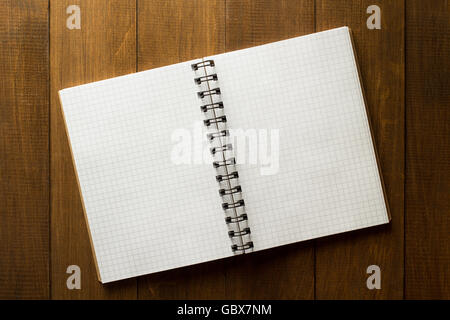 checked notebook on wooden background Stock Photo - Alamy
