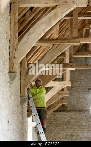 A workman in an Elizabethan barn with a rare hammerbeam roof, built in ...