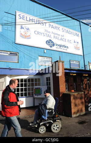A Crystal Palace fan with the club badge on a large banner behind ...
