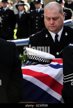Police Officers carry the casket in during the start of a funeral for ...