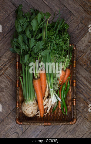 Wooden box of fresh peppers, carrots, lime, lemon, mint and lettuce on ...