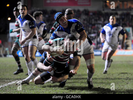 Leicester Tigers' Aaron Mauger (centre) is held as he tries to break ...