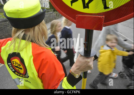 Lollipop Lady and school students crossing road England, UK Stock Photo ...