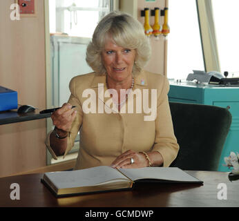 Queen Camilla signs the guest book during a visit to St Mungo's in ...