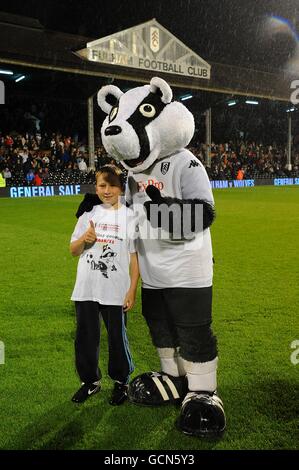 A competition winner poses with Fulham mascot Billy the Badger at half ...
