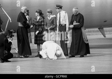 Pope John Paul II kneels down and kisses the ground at Cardiff airport ...