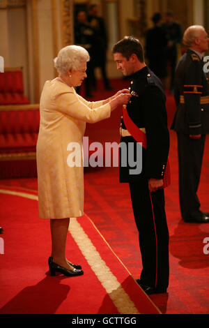 Queen Elizabeth II presents Sergeant Adam Swift, of the Coldstream ...