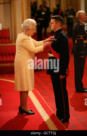 Queen Elizabeth II presents Sergeant Adam Swift, of the Coldstream ...